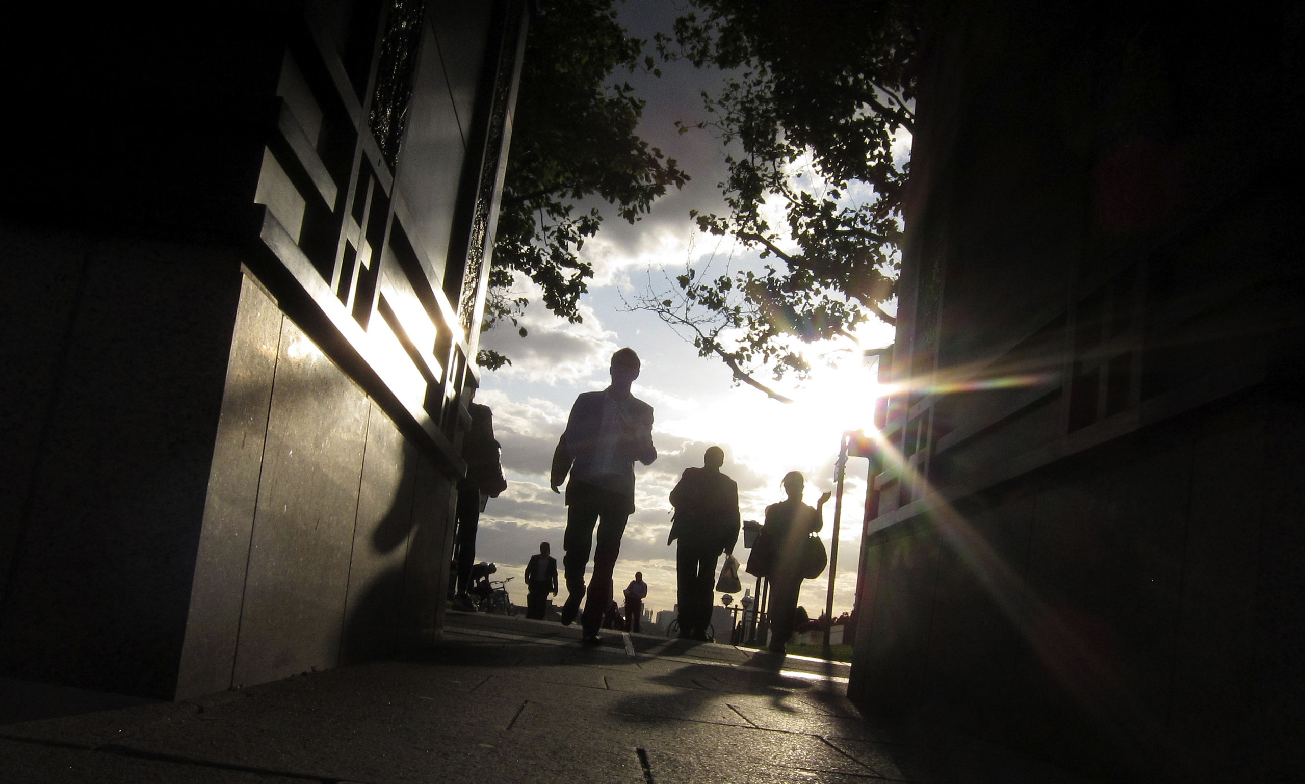 People walk through an archway as they make their way to the Canary ...